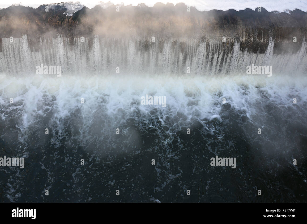 Dam to regulate the water level in the river. Falling water monochrome ...