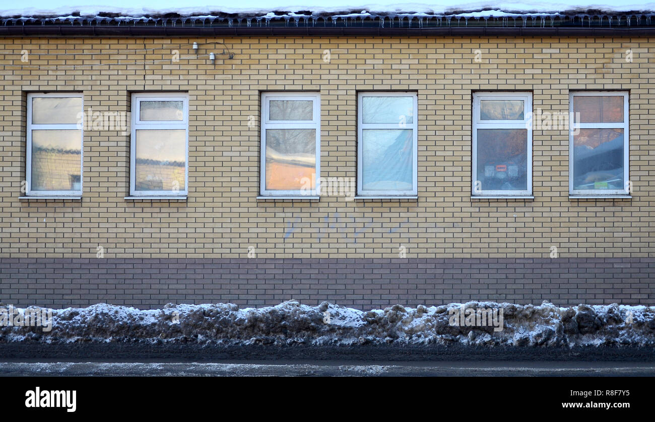 The texture of a brick wall with a few windows. Glazed windows in the ...