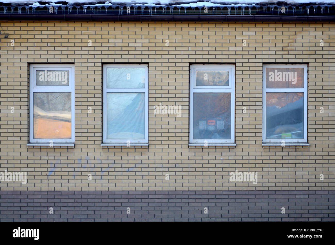 The texture of a brick wall with a few windows. Glazed windows in the ...