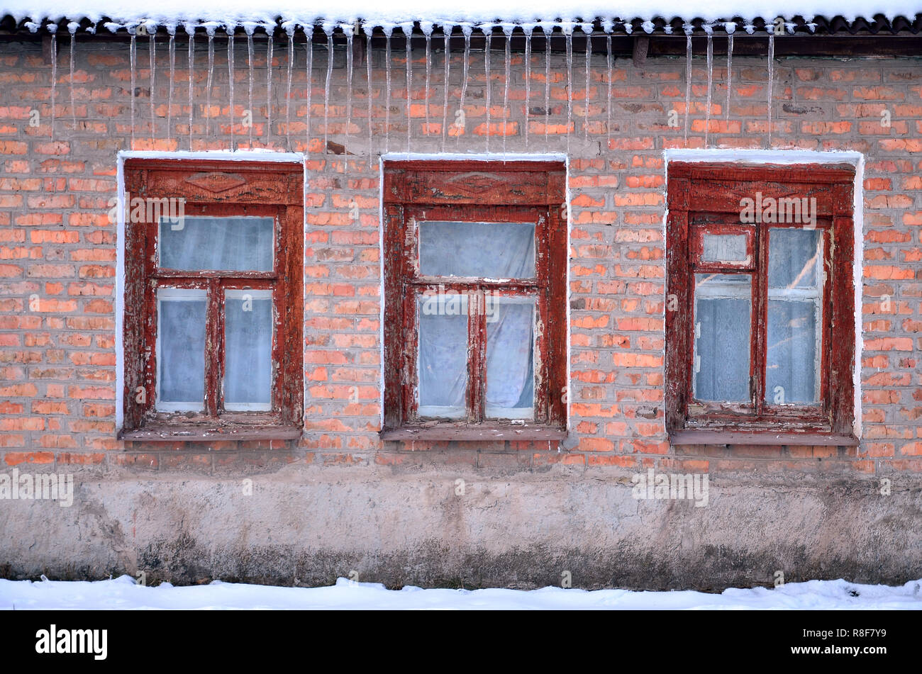 The texture of a brick wall with a few windows. Glazed windows in the ...