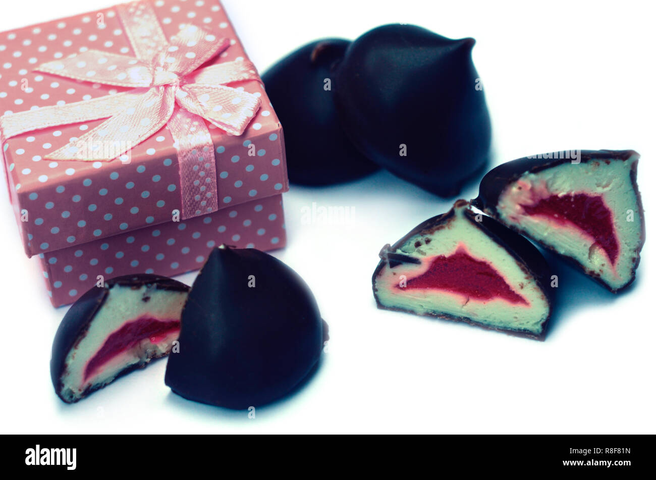 Pink dotted mini present-box with ribbon and chocolate cherry candies ...