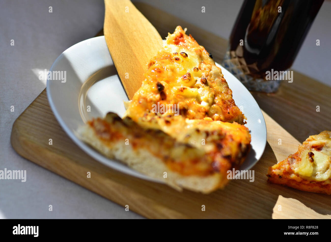 Pieces of pineapple pizza and glass cup of cola on wooden plate Stock ...