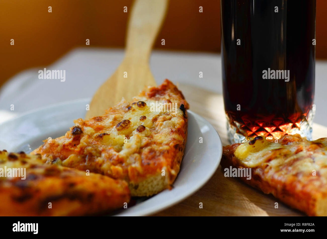 Pieces of pineapple pizza and glass cup of cola on wooden plate Stock ...