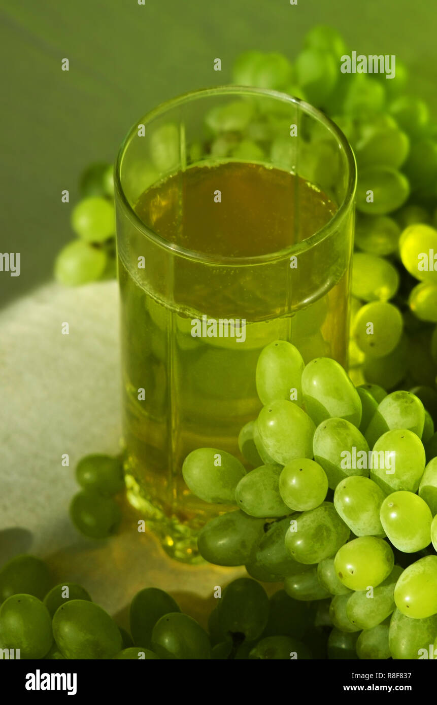 Yellow grape juice and wet bunches of green grapes Stock Photo - Alamy