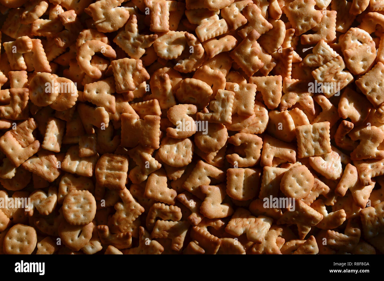 A lot of small yellow salted crackers in the form of printed English ...