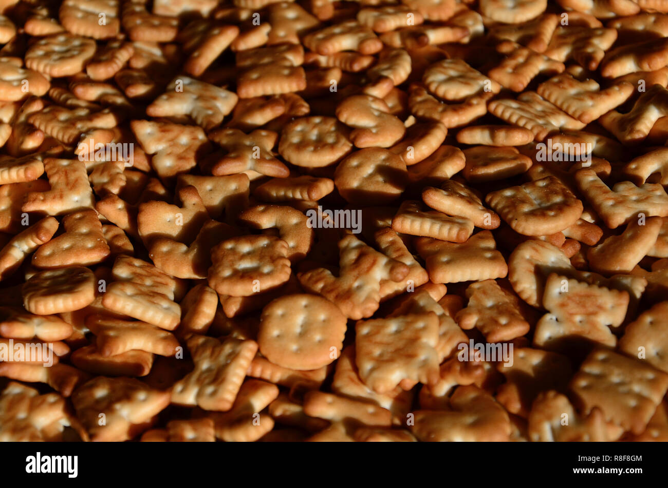 A lot of small yellow salted crackers in the form of printed English ...