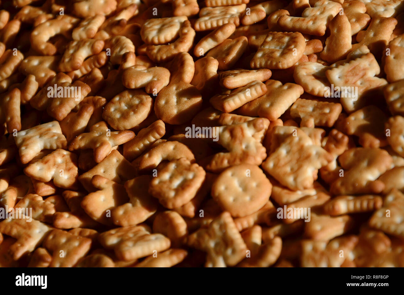 A lot of small yellow salted crackers in the form of printed English ...