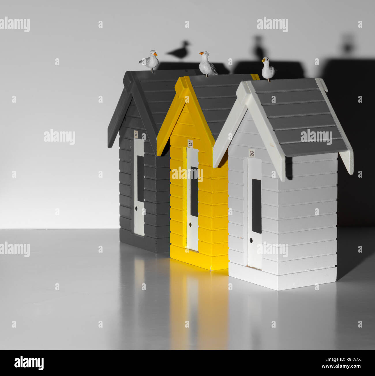 Wooden beach huts lined up with the yellow beach hut left coloured ...