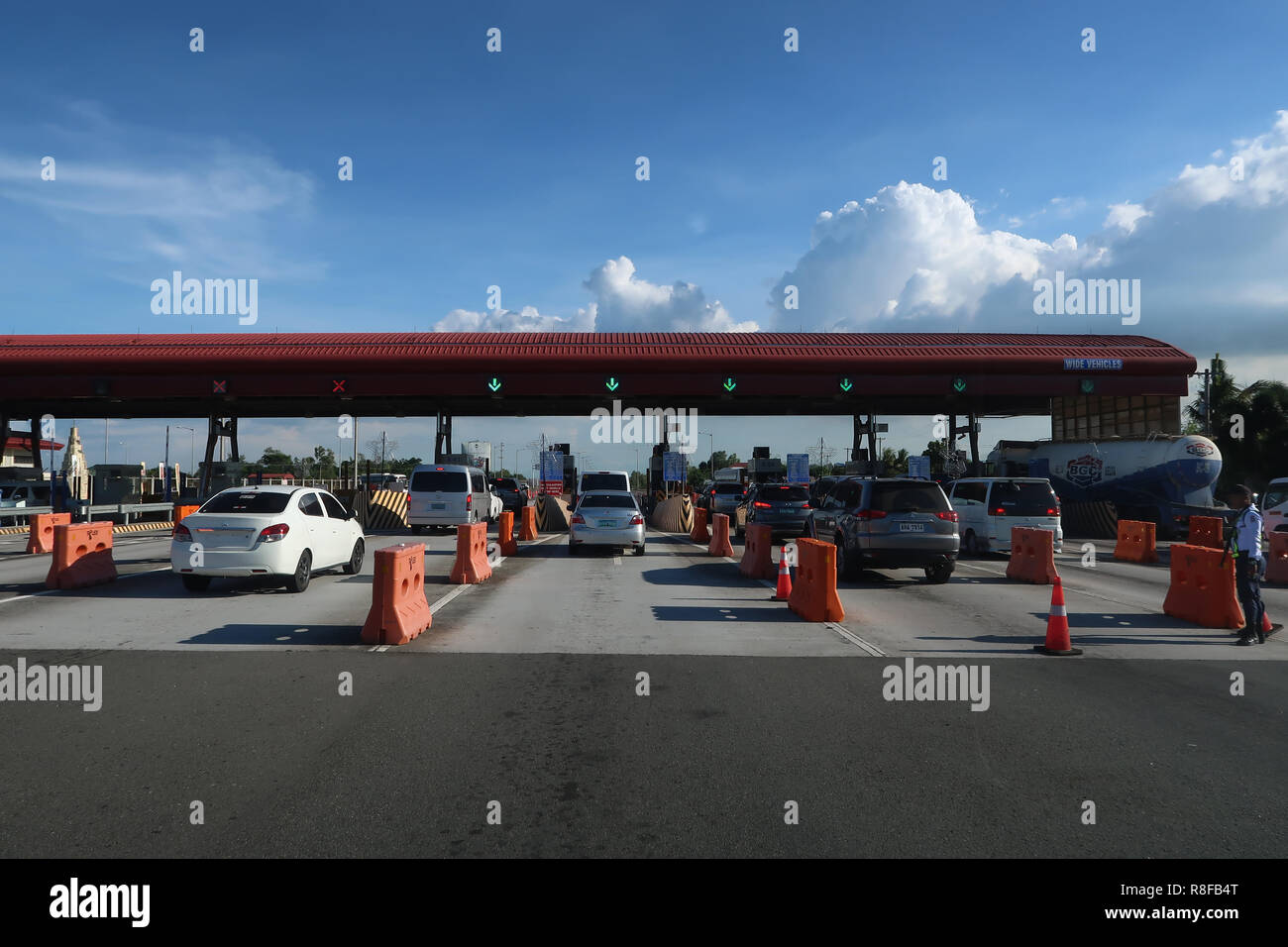 Cars pass through a tollbooth station in the North Luzon Expressway ...