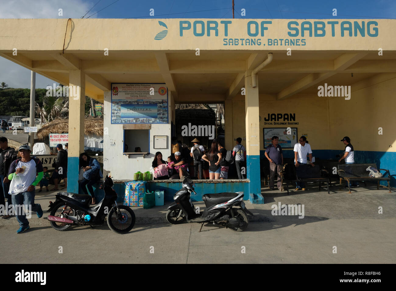 Passengers wait for a ferry boat at the port of Sabtang the ...