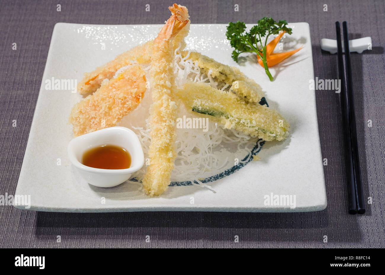 different fish and vegetables tempura with citrus fruit sauce on a bed ...