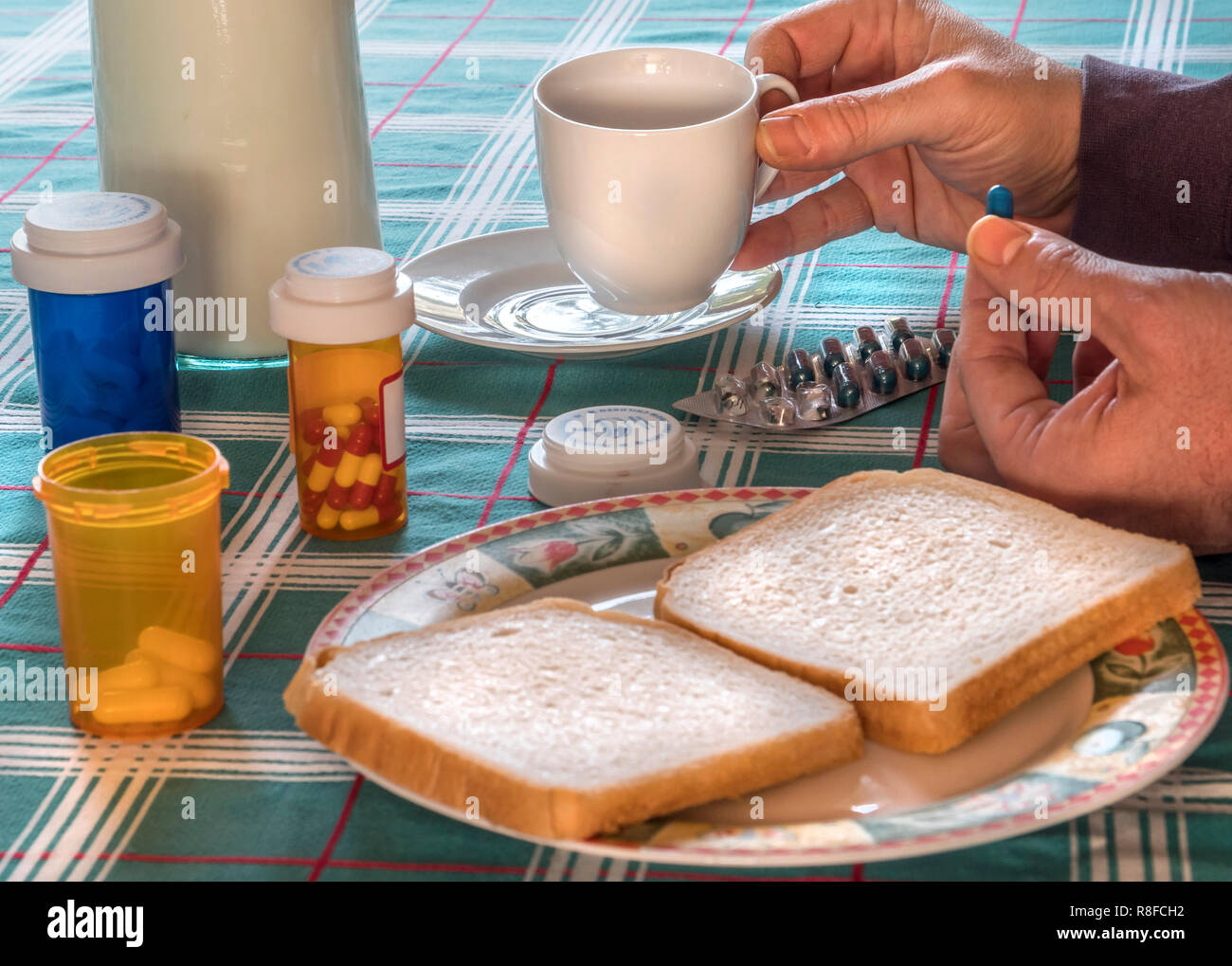 Person takes medication during breakfast, conceptual image Stock Photo ...