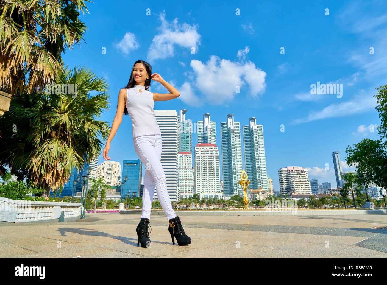Beautiful woman posing - standing, cross legged, enjoying and happiness ...