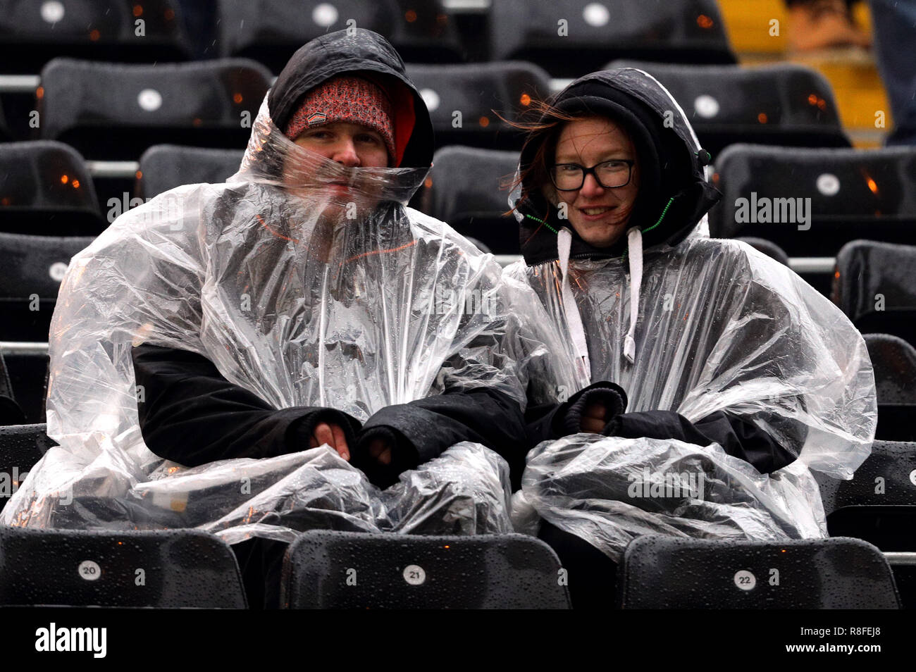 Fans shelter from the rain under a poncho in the Graham Hughes stand ...