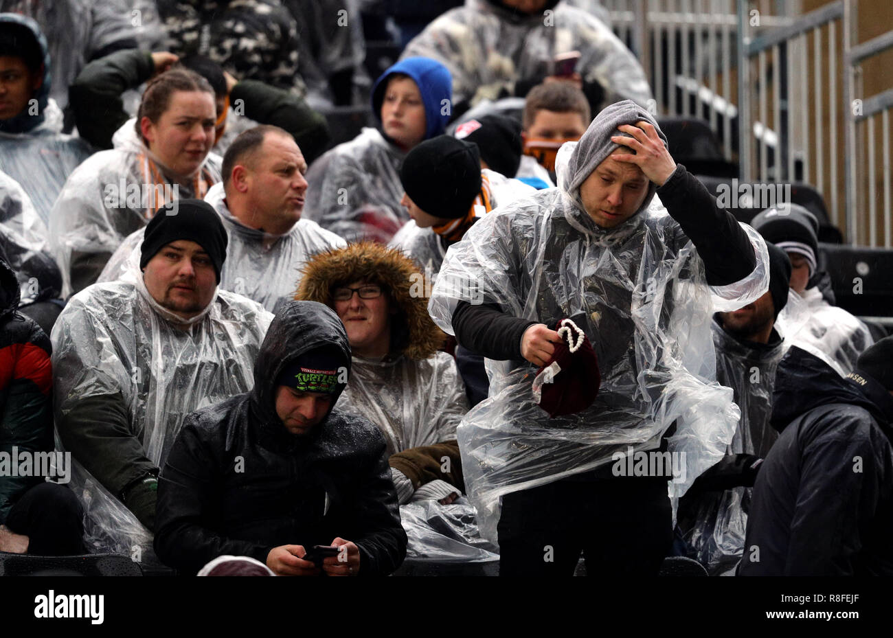 Fans shelter from the rain under a poncho in the Graham Hughes stand ...