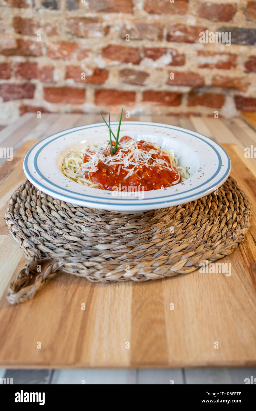 spaghetti bolognese with tomato sauce, meat and cheese in a wooden ...