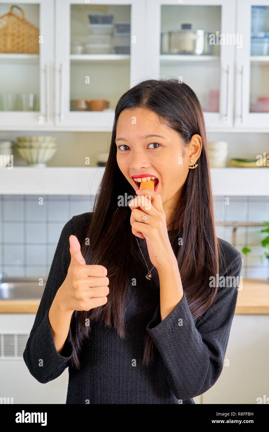 Beautiful woman posing - thumbs up, eating and looking at camera Stock ...
