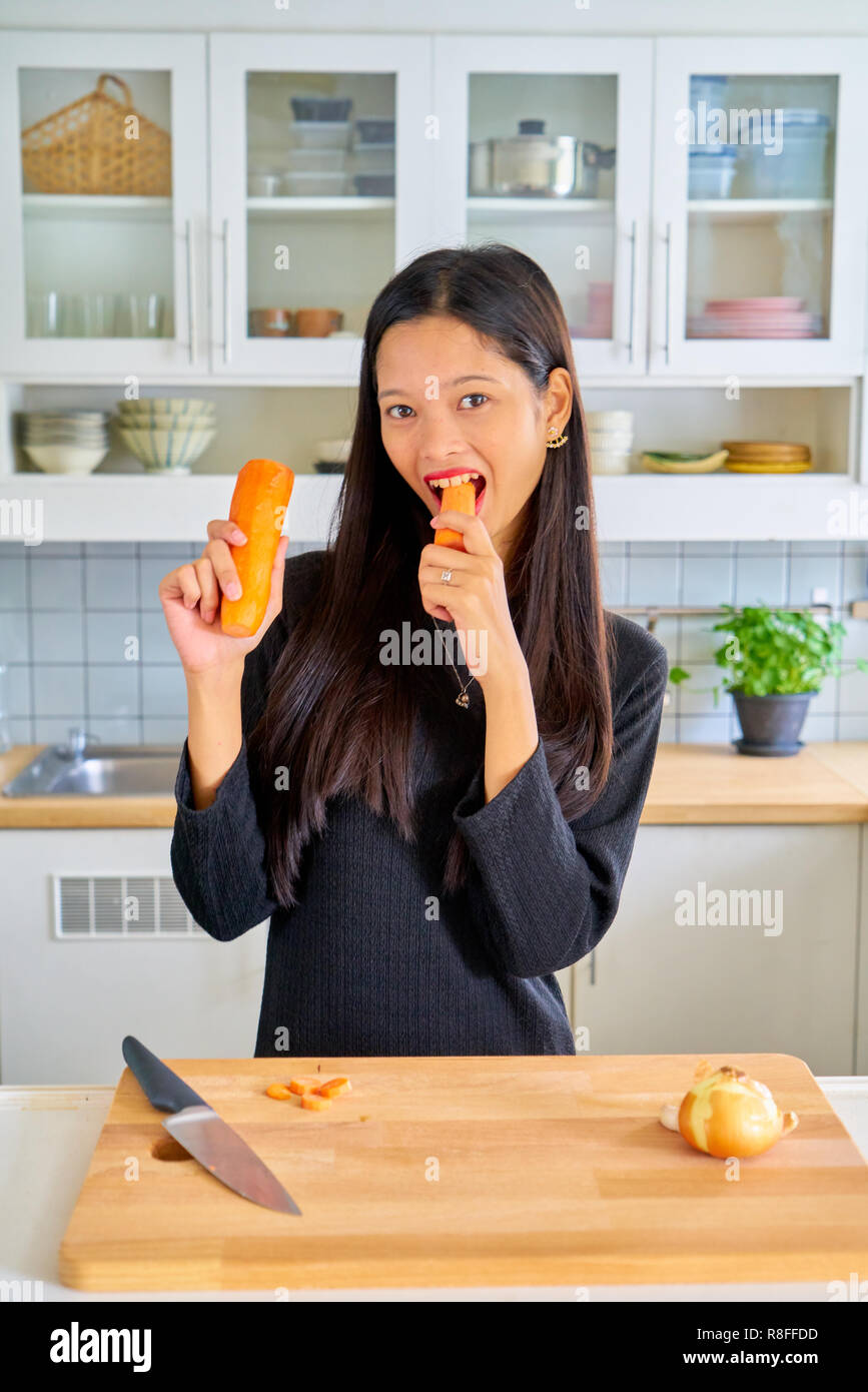 Beautiful woman posing - standing, showing the other carrot and eating ...