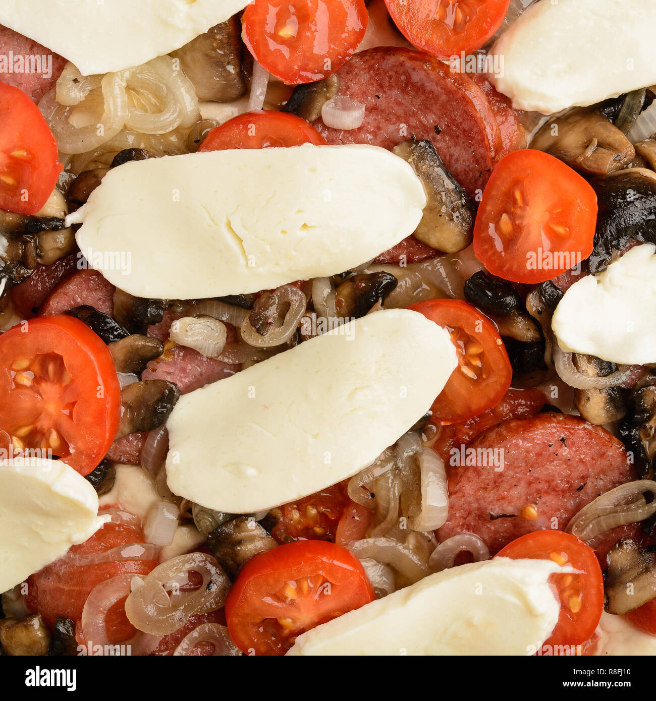 Overhead view of homemade pizza with pepperoni, mushrooms, tomatoes and ...
