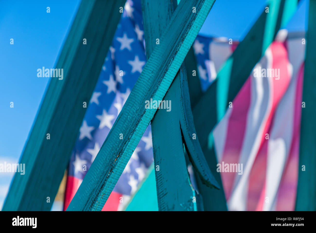 Close up of turquoise wooden post with america flag in the background ...