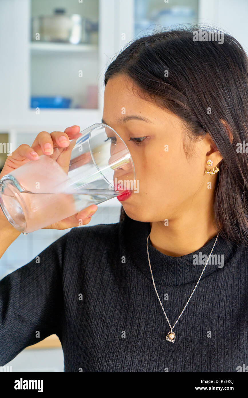 Beautiful woman posing - drinking water, thinking Stock Photo - Alamy