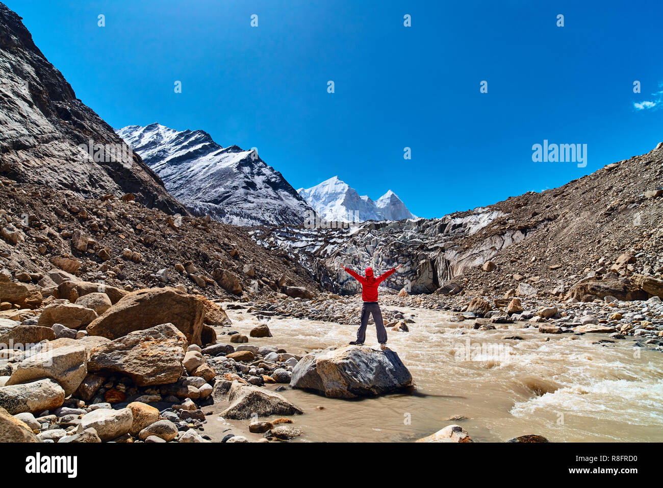 Man with hands in the air standing in Himalaya mountains, near by Ganga ...