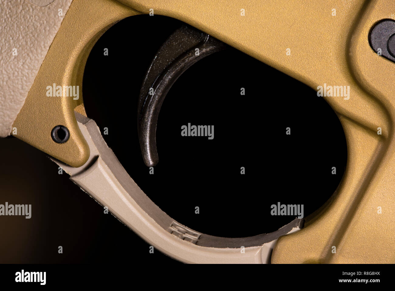 Trigger on an AR-15 in a gold color on a dark background Stock Photo ...