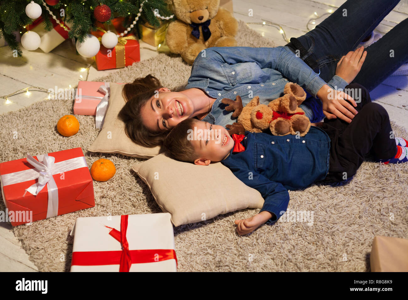 mother and son lay Christmas tree with gifts the new year Stock Photo ...