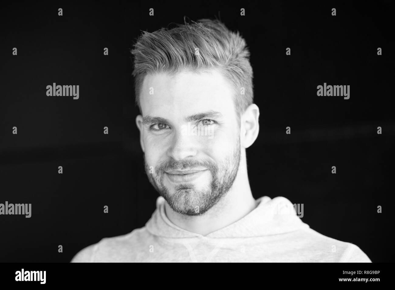 Man with bristle on smiling face, black background. Metrosexual concept ...