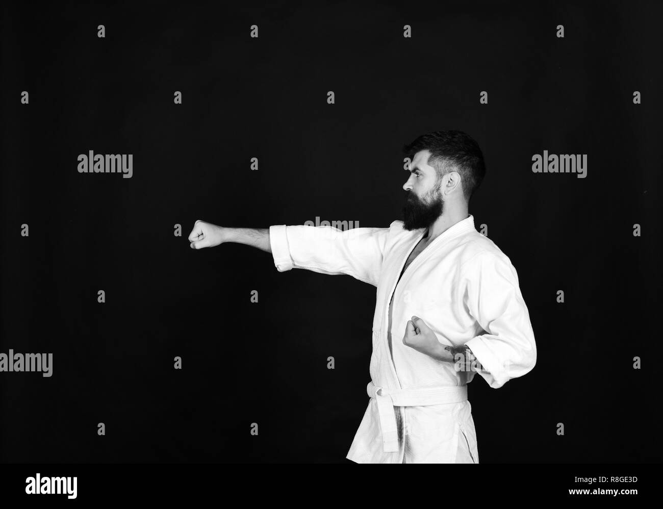 Karate man with strict face in uniform. Man with beard in white kimono ...