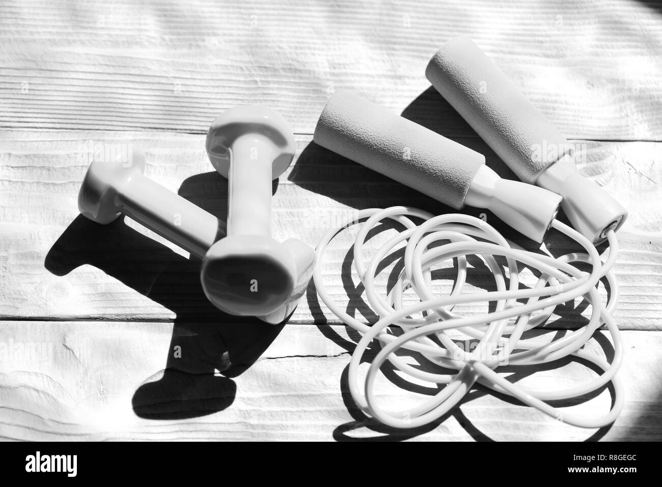 Barbells and messy skipping rope placed crosswise. Healthy shape and ...