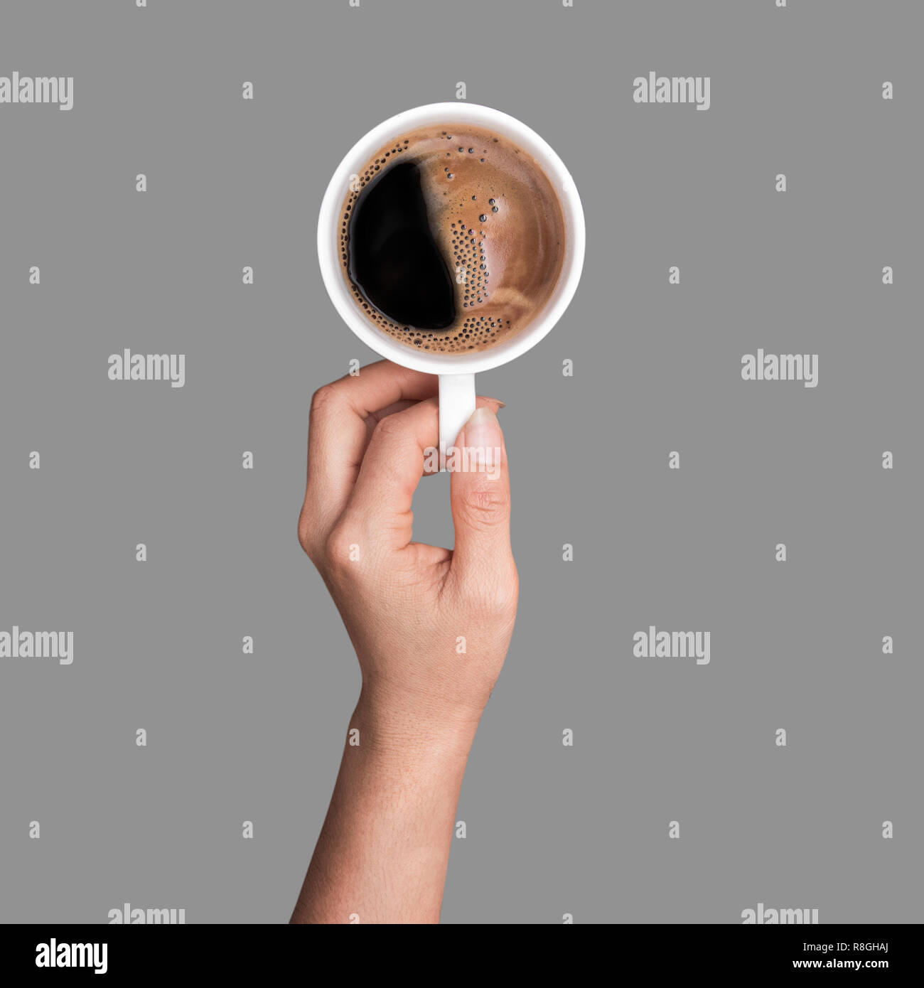 left hand holding cup of coffee isolated on grey background with ...