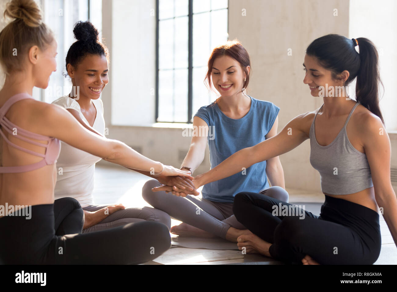 Four beautiful cheerful girls putting hands together Stock Photo - Alamy