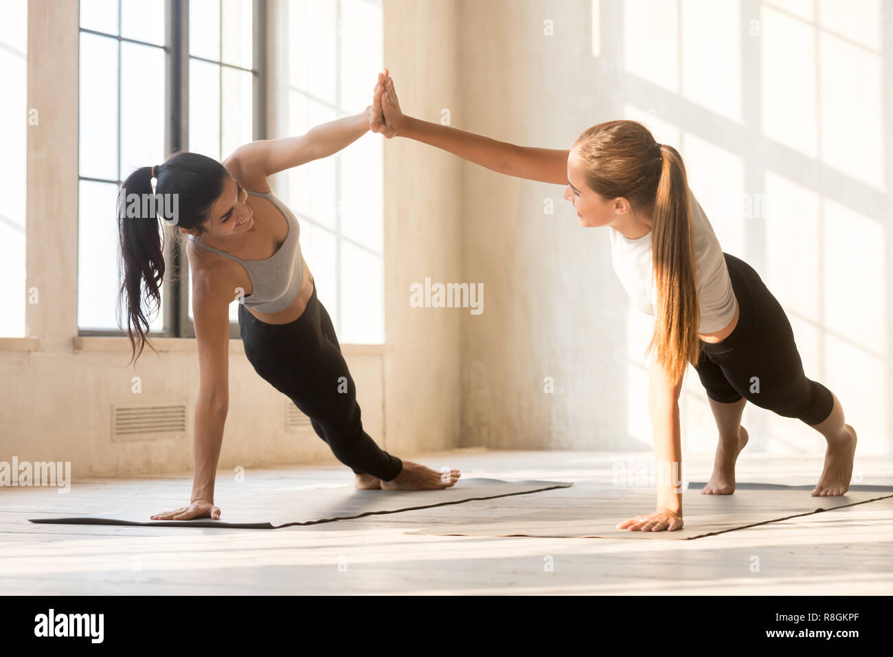 Girls doing side plank and holding hands Stock Photo - Alamy