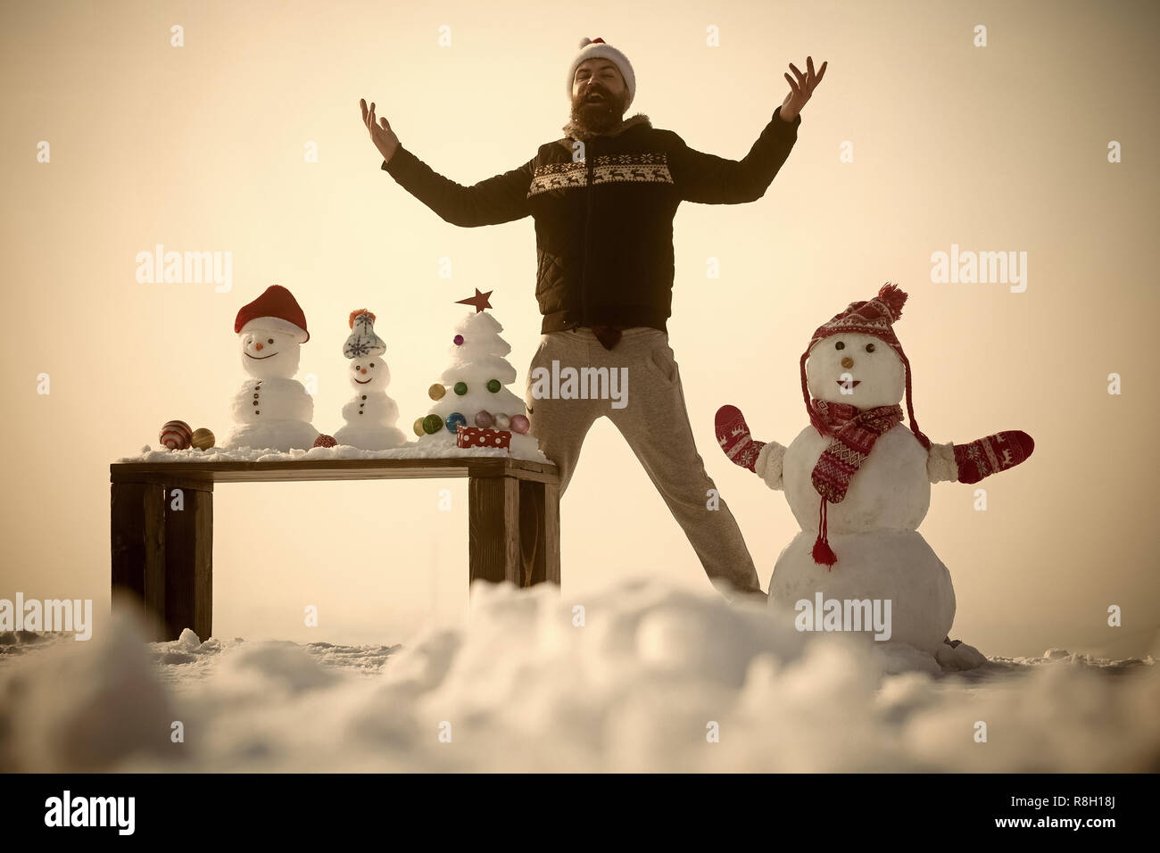 Hipster and snowman with raised hands on white sky Stock Photo - Alamy