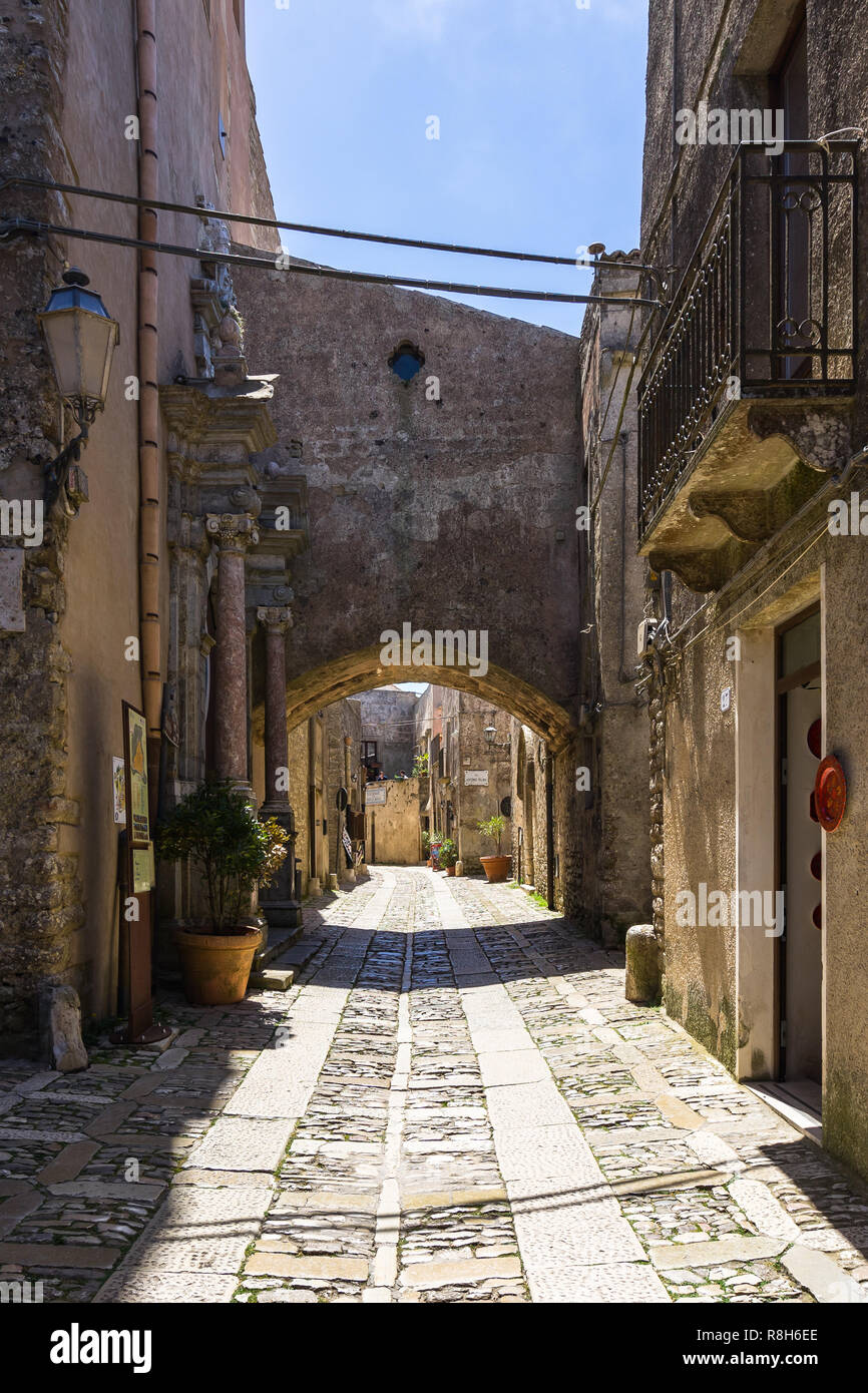 A typical cobbled street passing under stone arch in the historic town ...