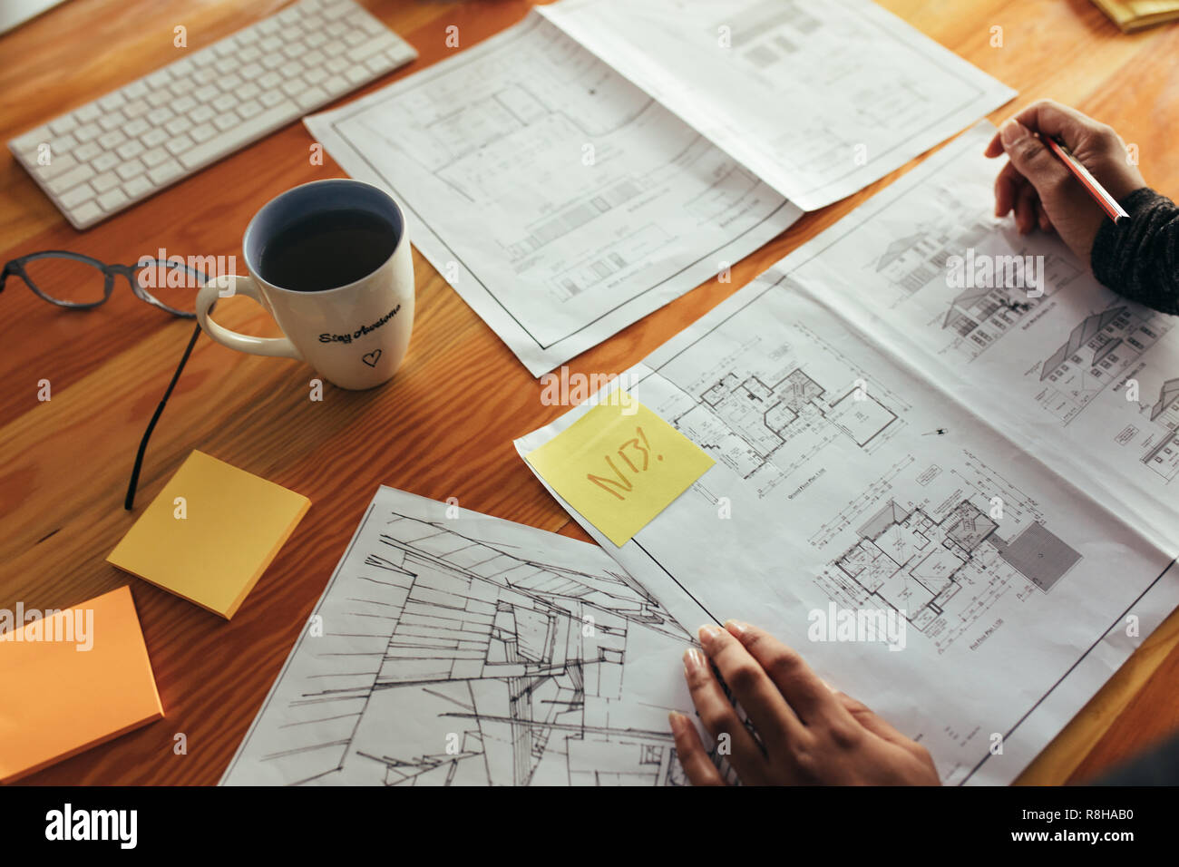 Cropped shot of woman architect working on floor plan of a building ...