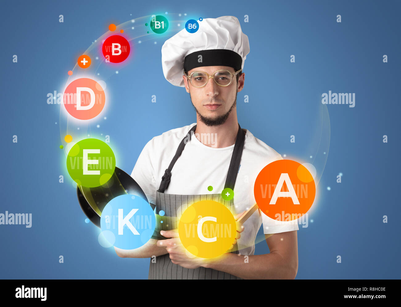 Handsome cook with kitchen instruments and vitamin concept Stock Photo ...