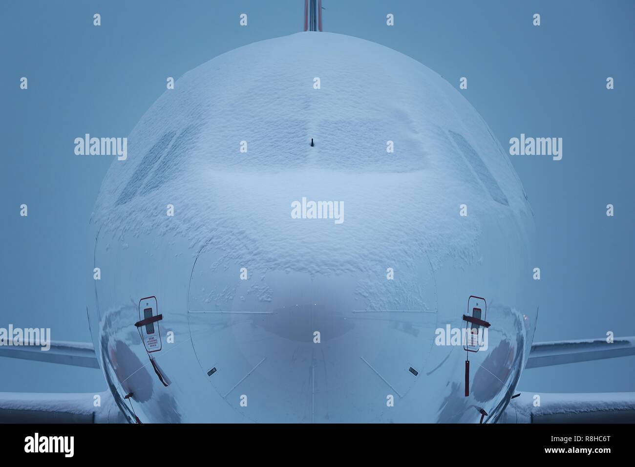 Winter morning at airport. Airplane covered by snow waiting for deicing ...