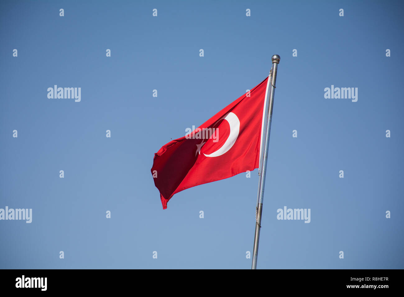 Turkish flag with red and white moon, blue sky Stock Photo - Alamy