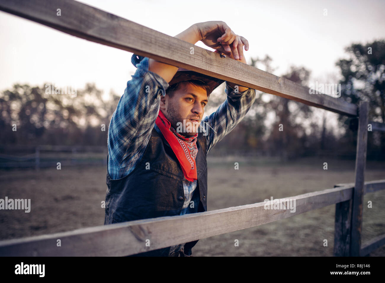 Young cowboy in leather jacket and hat poses on ranch, western. Vintage ...