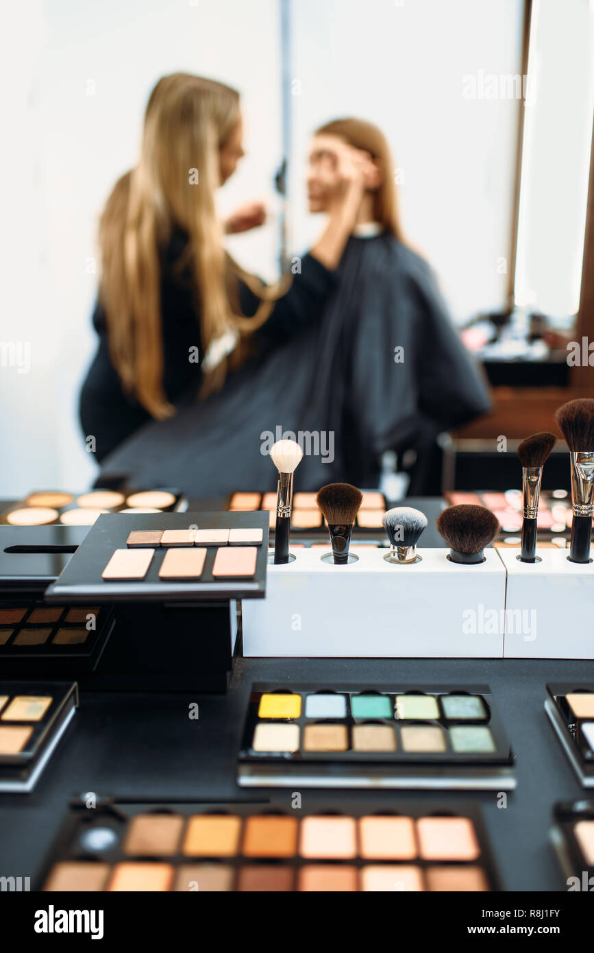Makeup artist works with customers face, woman in make-up shop. Female ...
