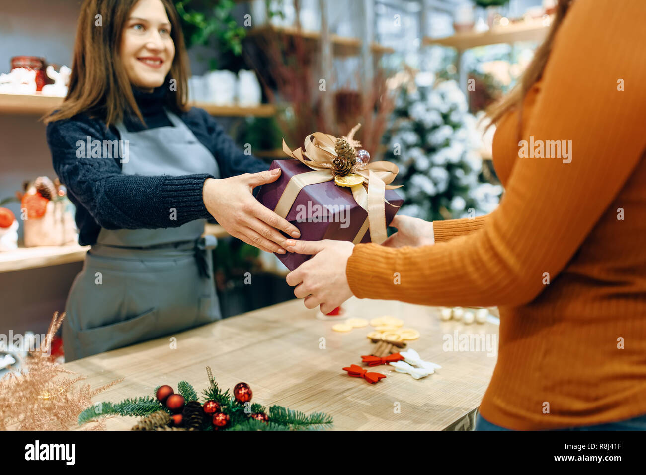Female seller gives to customer christmas gift box with handmade ...