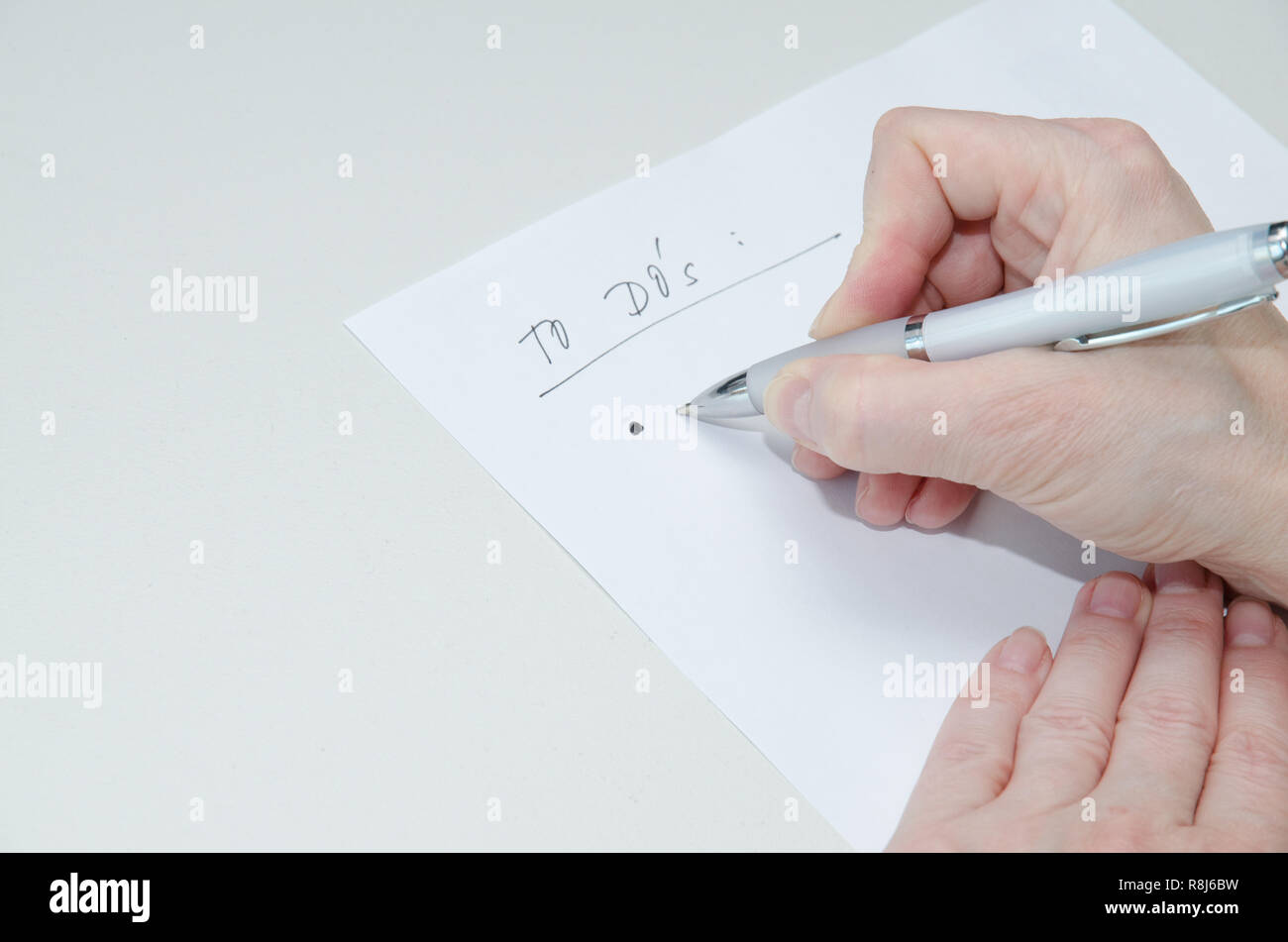hand with pen and white to do´s list paper Stock Photo - Alamy