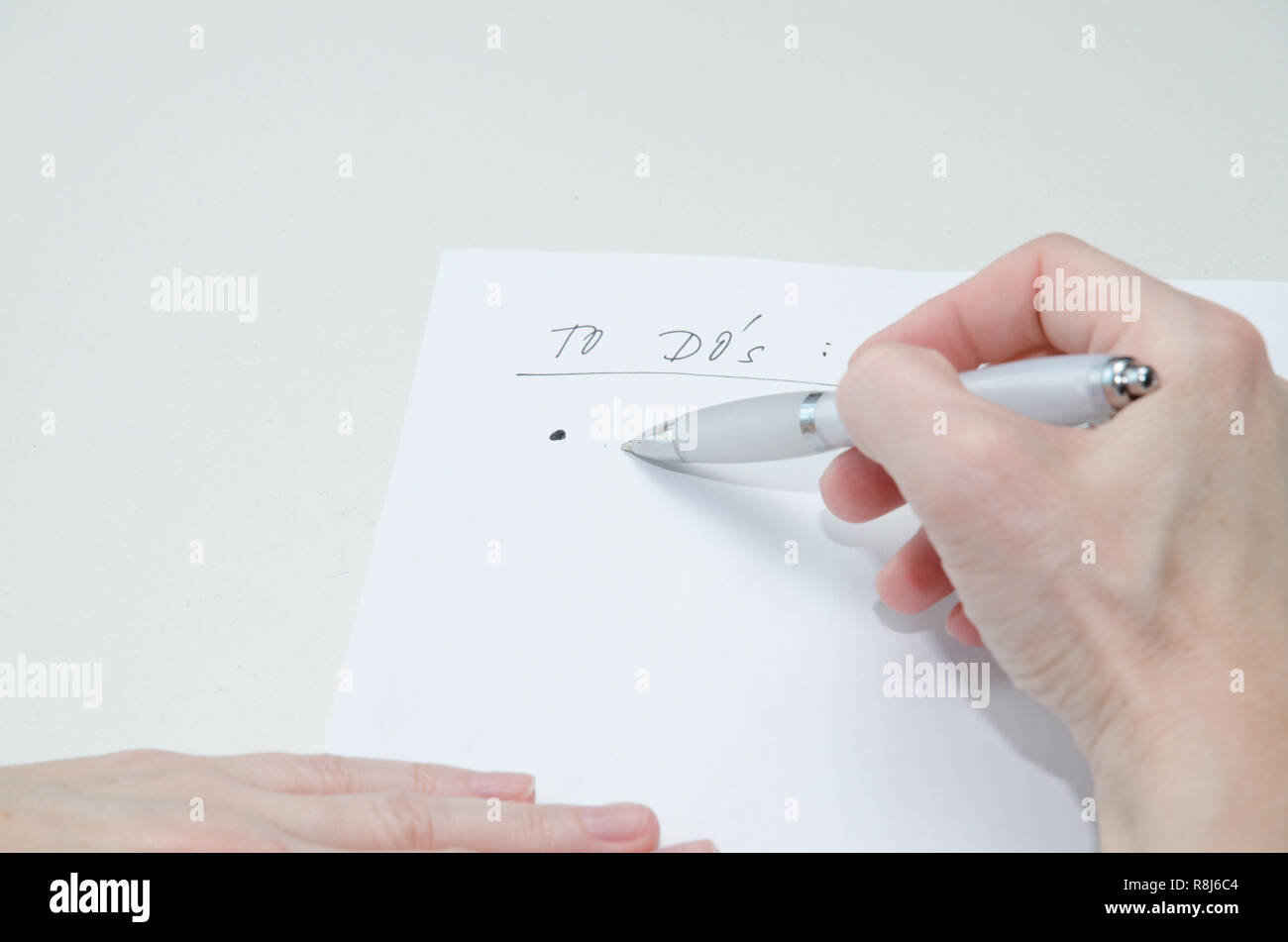 hand with pen and white to do´s list paper Stock Photo - Alamy
