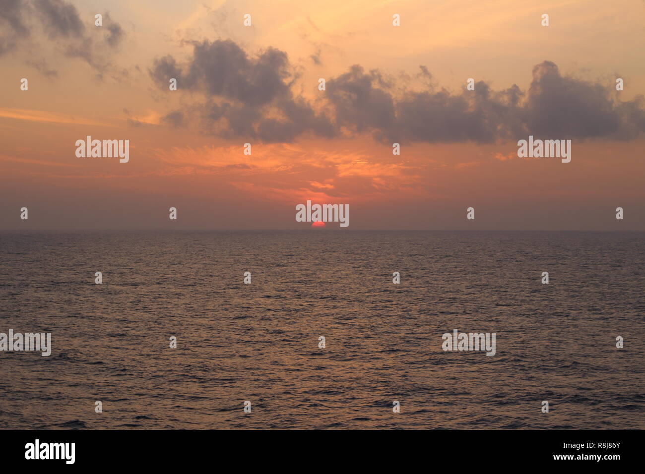 Distant sunset with clouds at sea in the gulf of Mexico Stock Photo - Alamy