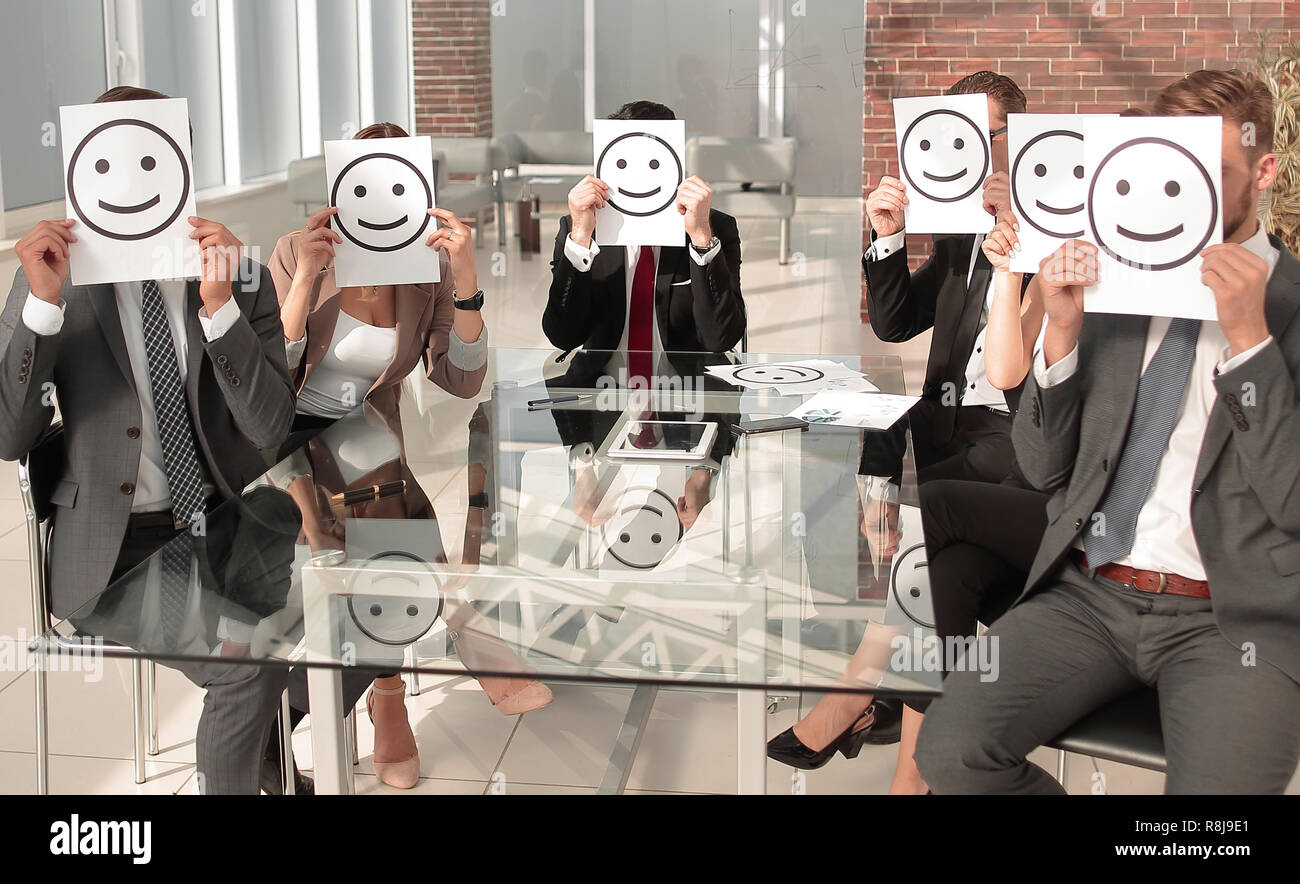 Business Team holding a paper with a positive smiley Stock Photo - Alamy