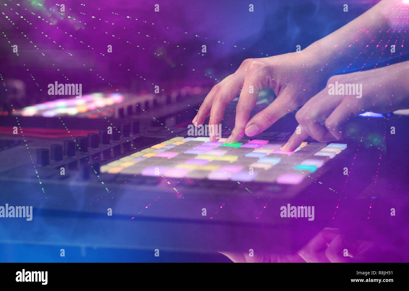 Hand mixing music on midi controller with party club colors around ...
