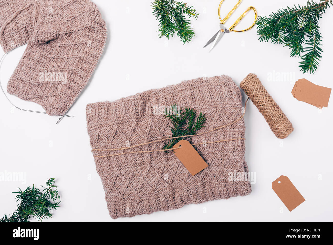 Handmade wool sweater with rustic pattern lies on white table among ...
