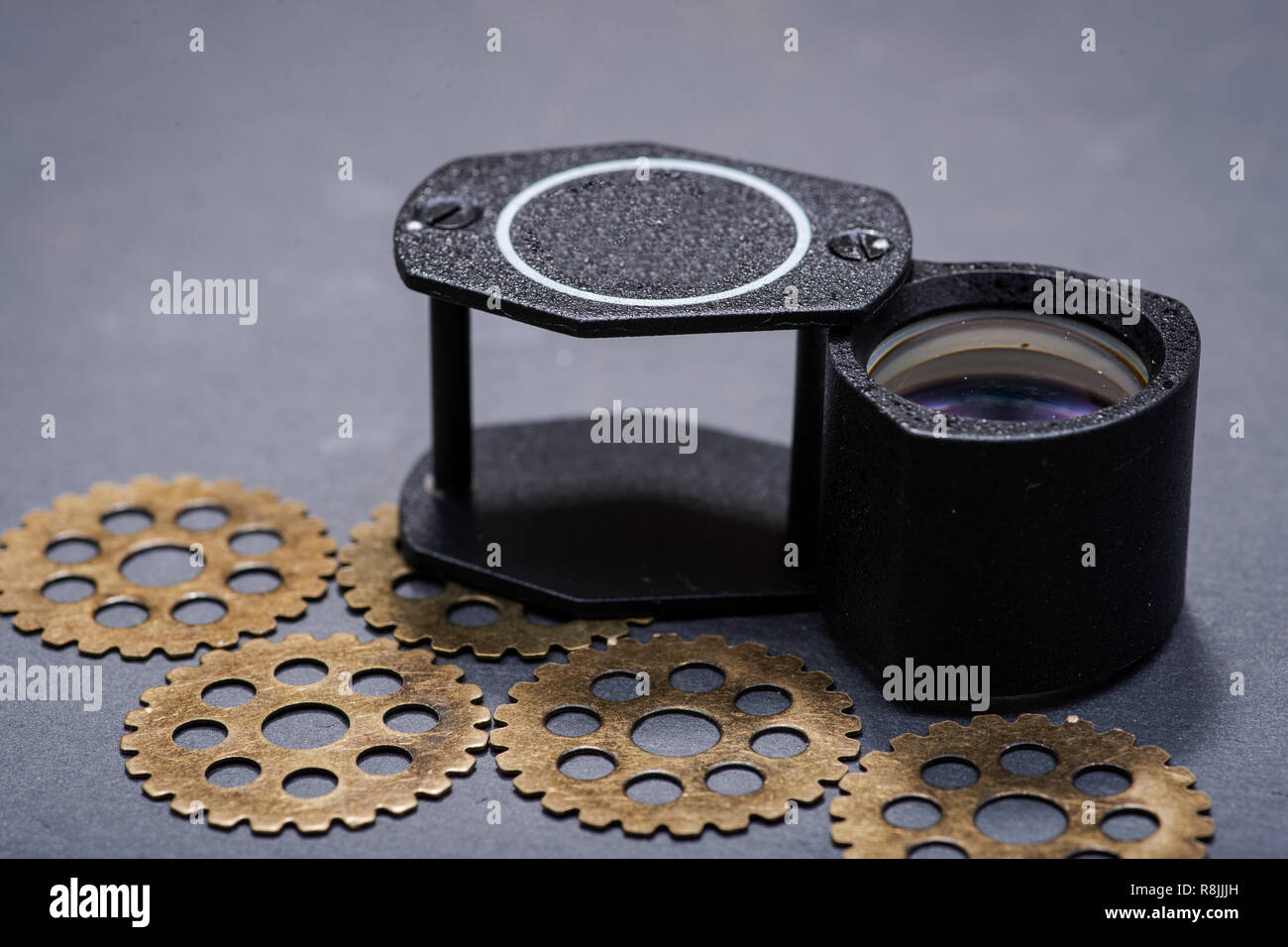 Loupe, magnifying glass and old vintage antique hour metal gears ...
